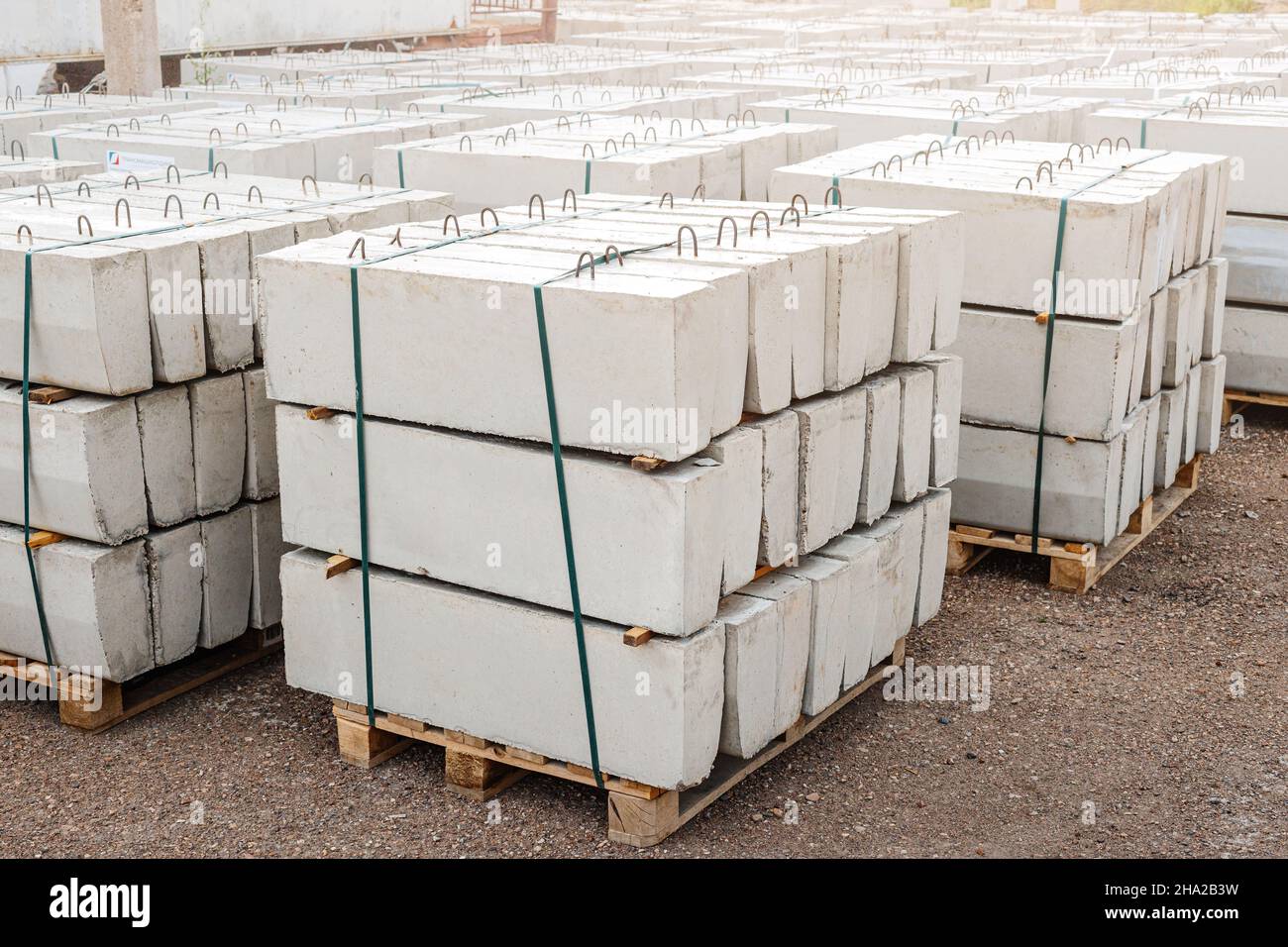 A lot of building cement blocks in an extensive open-air warehouse ...
