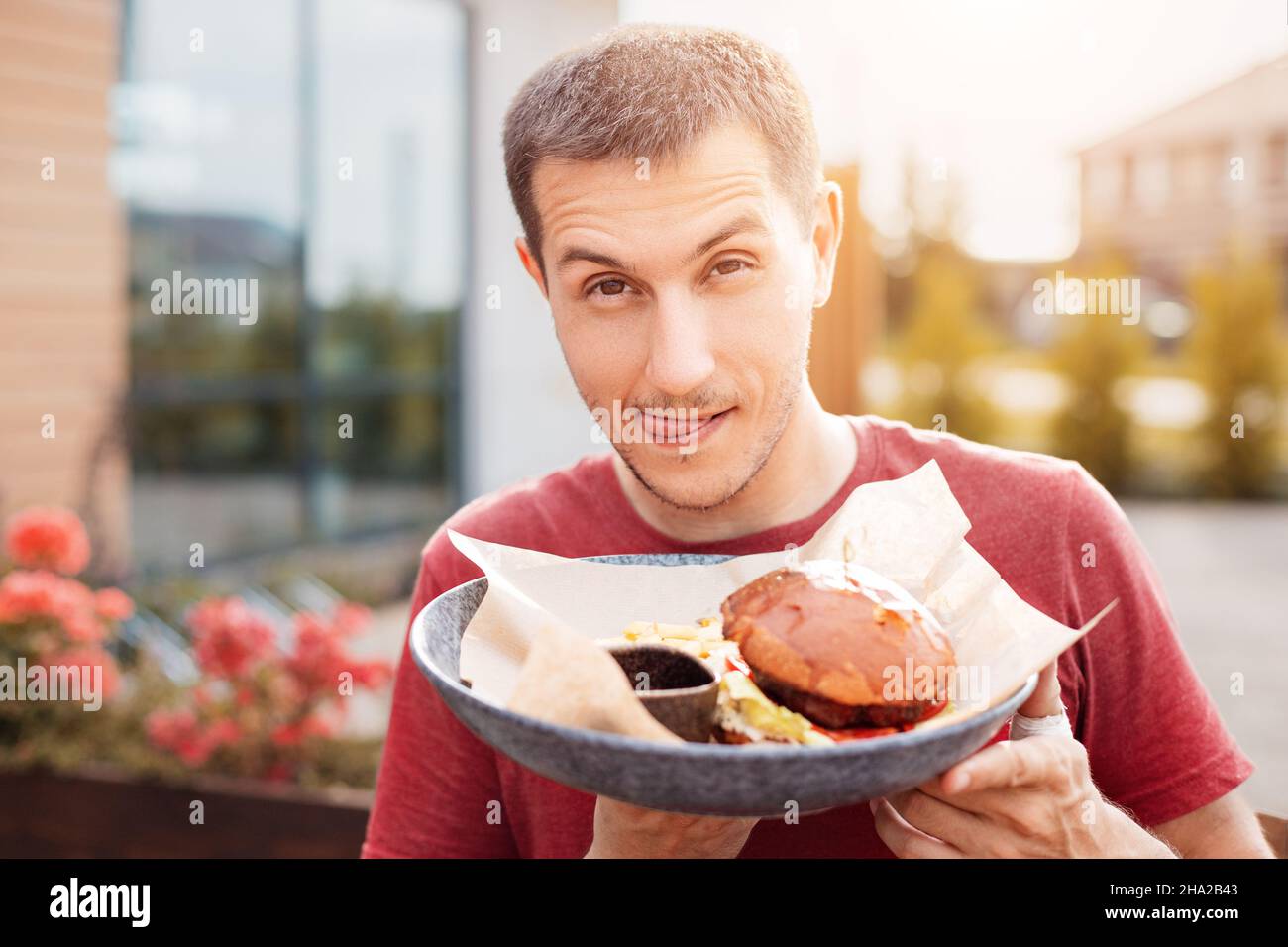 A funny man licks his lips and leers at a fresh delicious and greasy ...