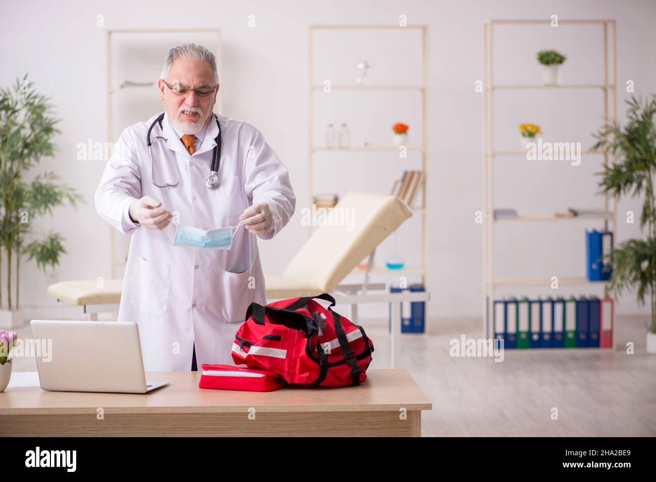 Old doctor in first aid concept Stock Photo - Alamy