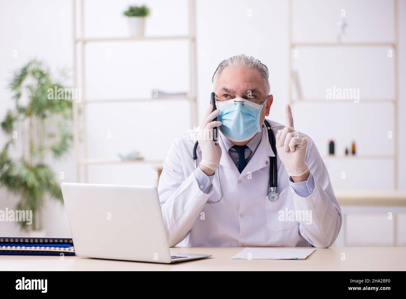 Old doctor working in the clinic Stock Photo - Alamy