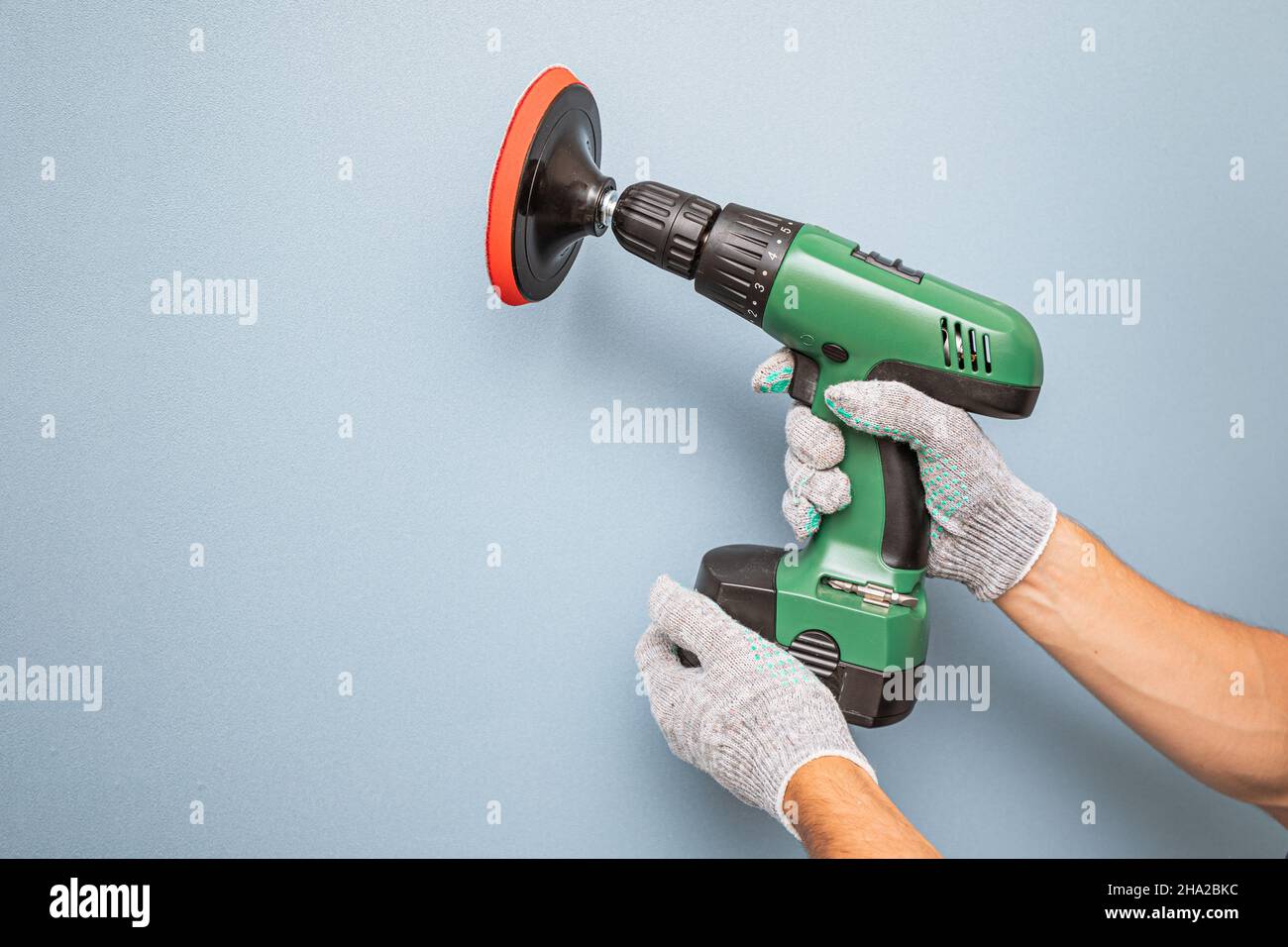 grinding wall or paint removal with disc sanding hand machine. Worker ...