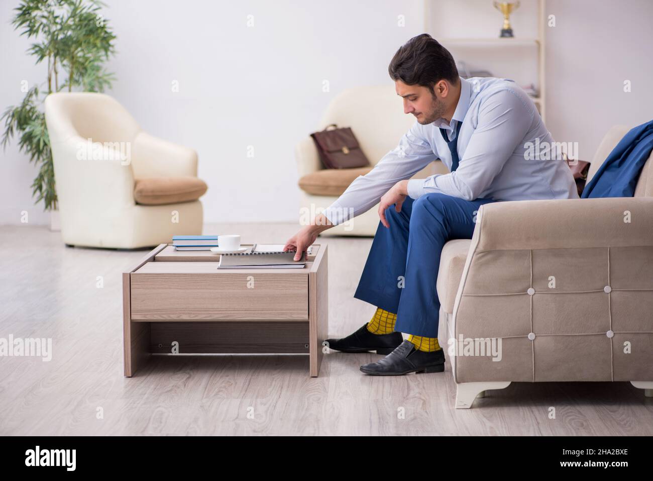 Young male employee waiting for business meeting Stock Photo - Alamy