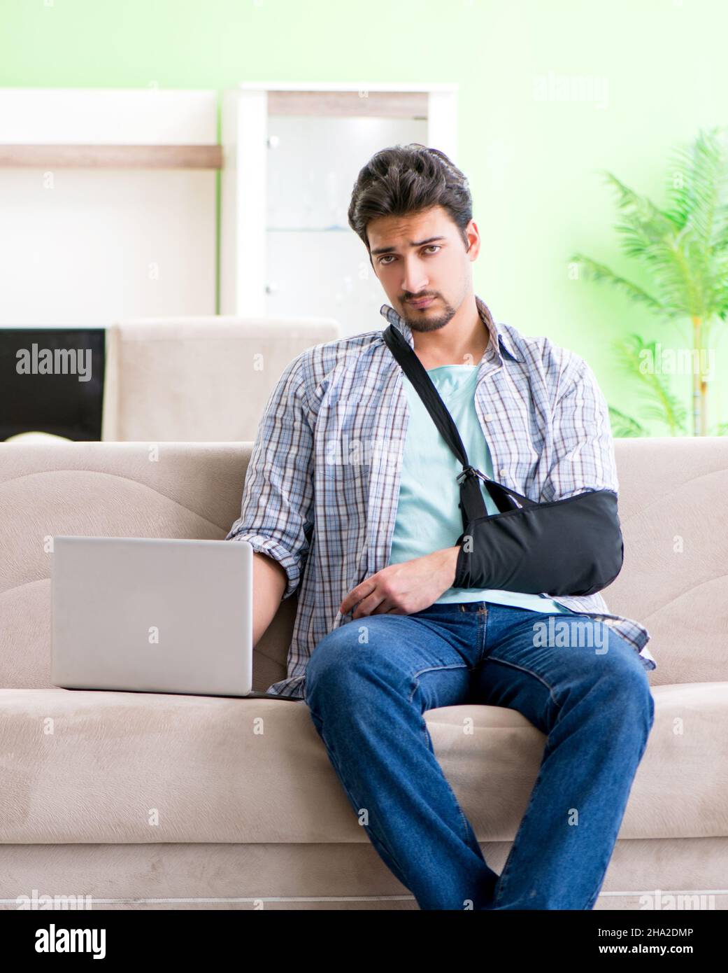 The young student man with hand injury sitting on the sofa Stock Photo ...