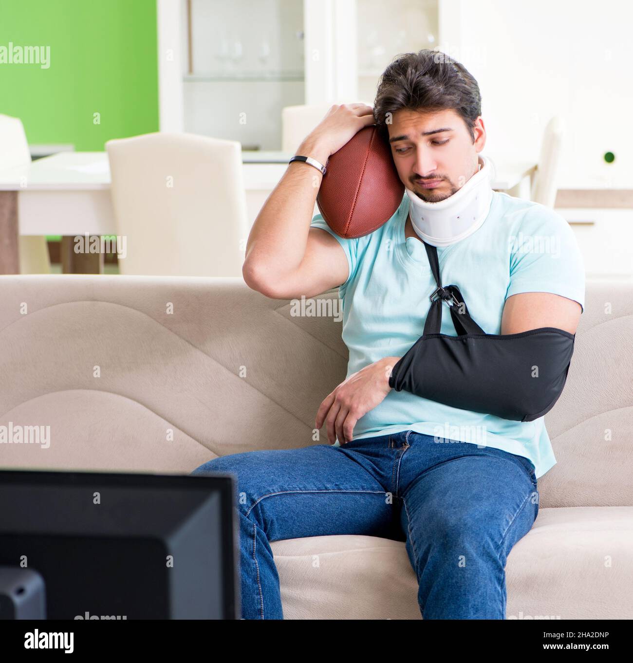 The man with neck and arm injury watching american football on tv Stock ...