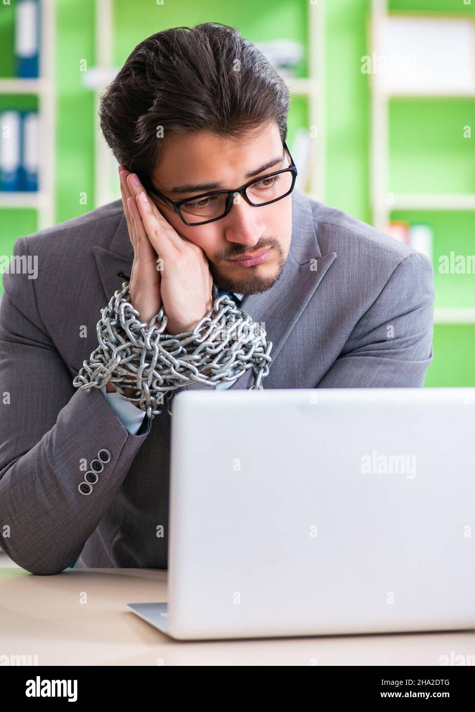 The employee chained to his desk due to workload Stock Photo - Alamy