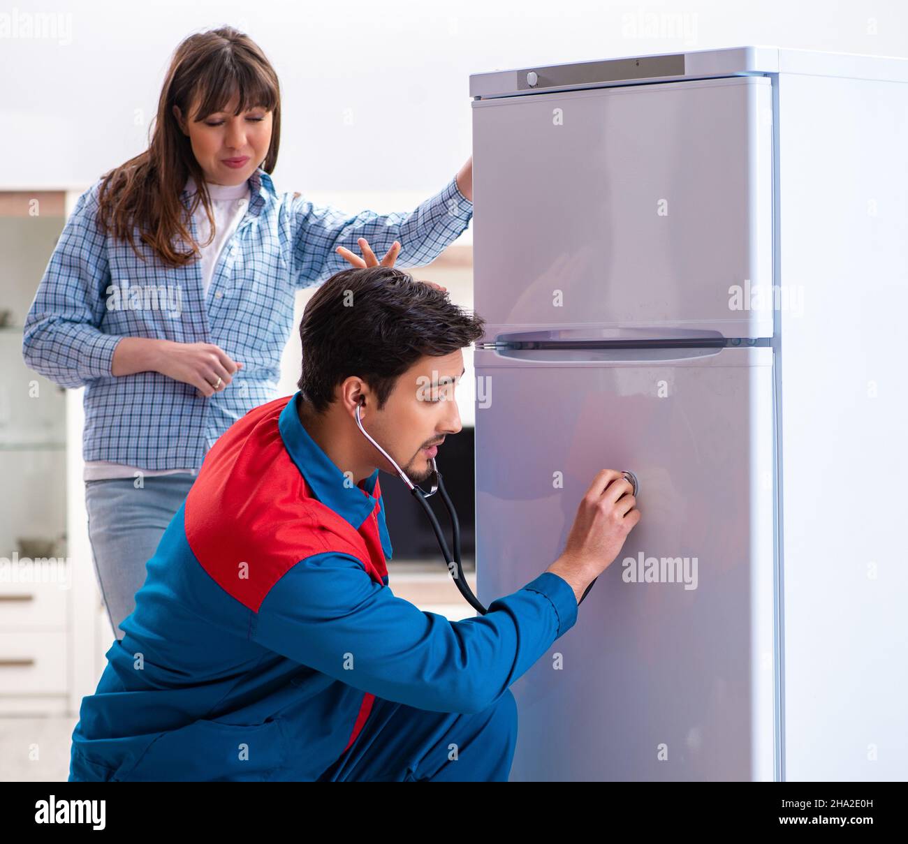The man repairing fridge with customer Stock Photo - Alamy