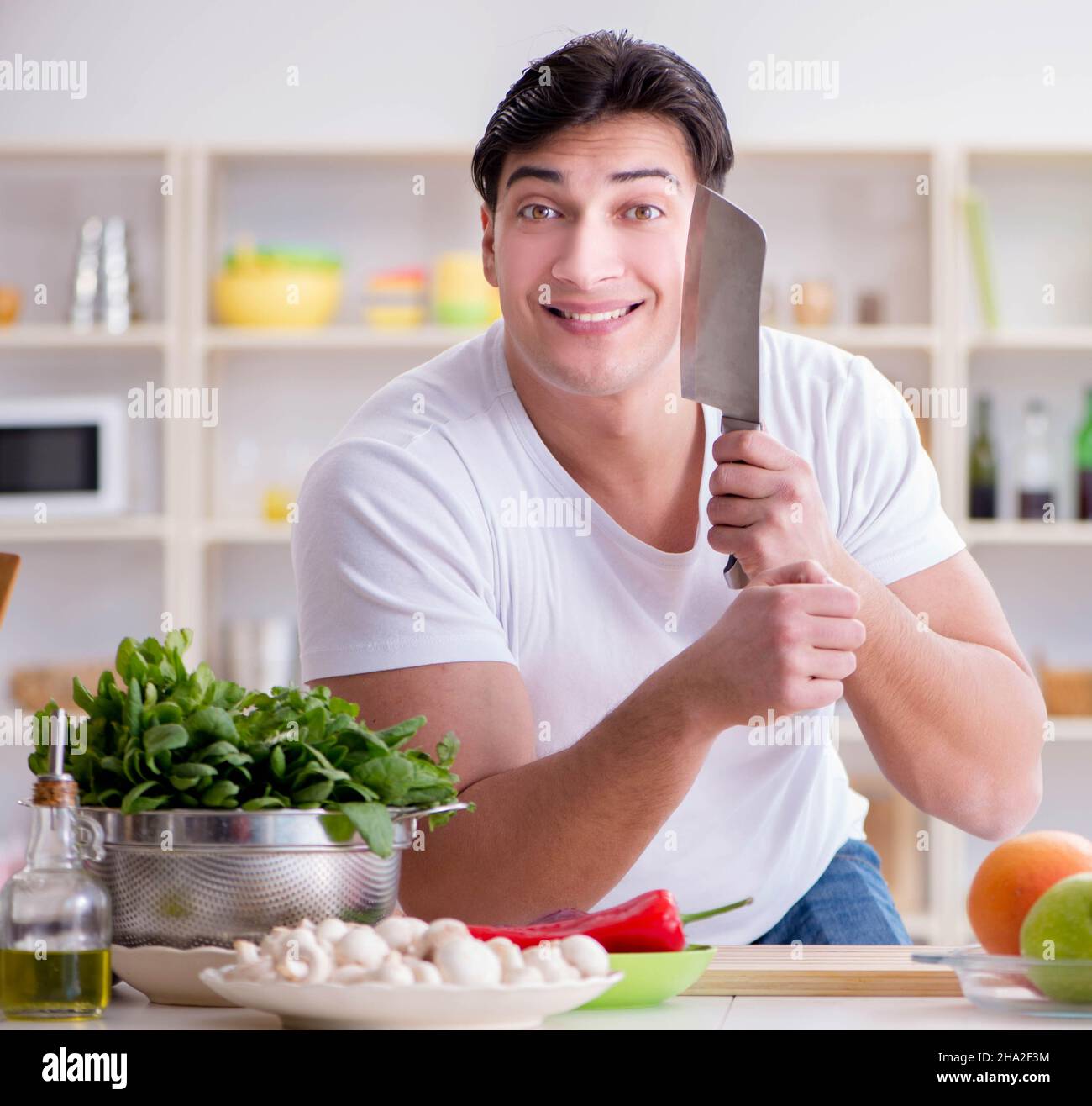 The young male cook working in the kitchen Stock Photo - Alamy