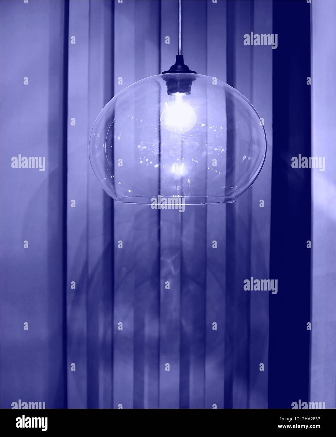 Contemporary glass lamp illuminating part of dark room in house with ...