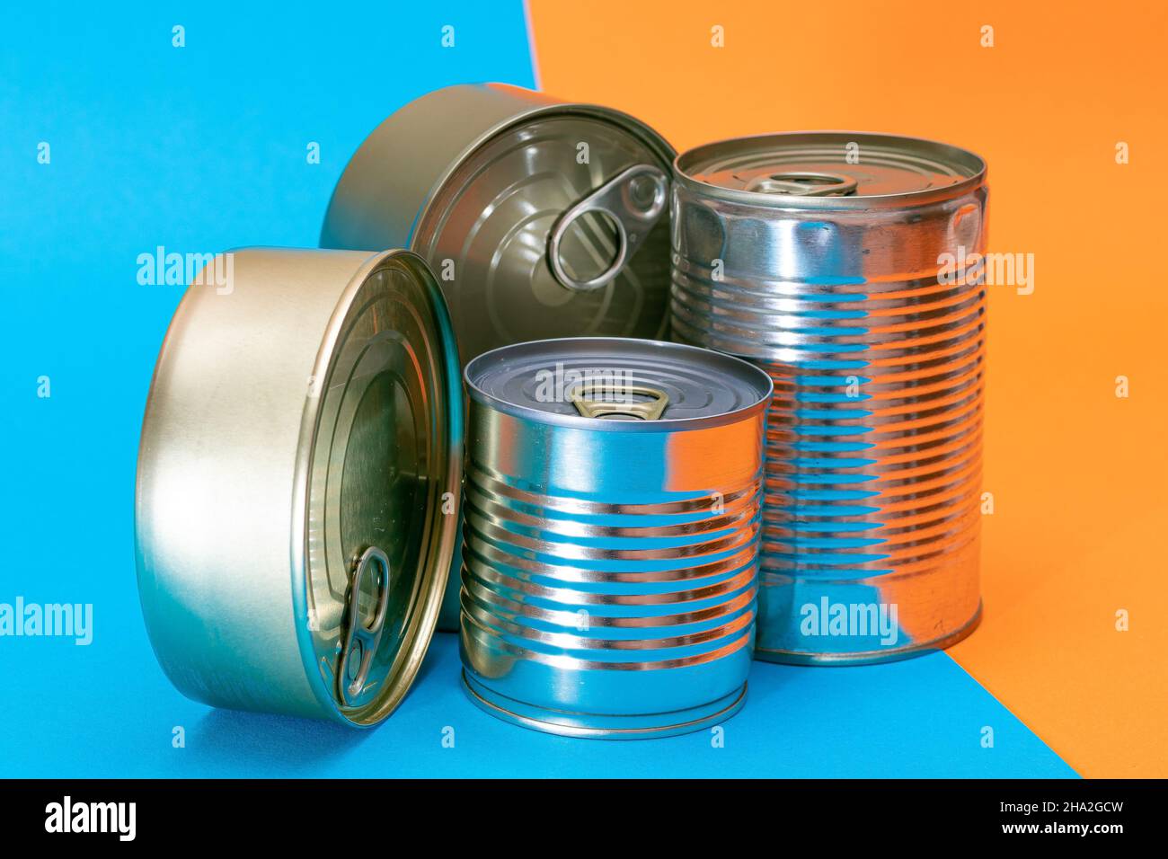 A Group of Stacked Tin Cans with Blank Edges on Split Blue and Orange ...