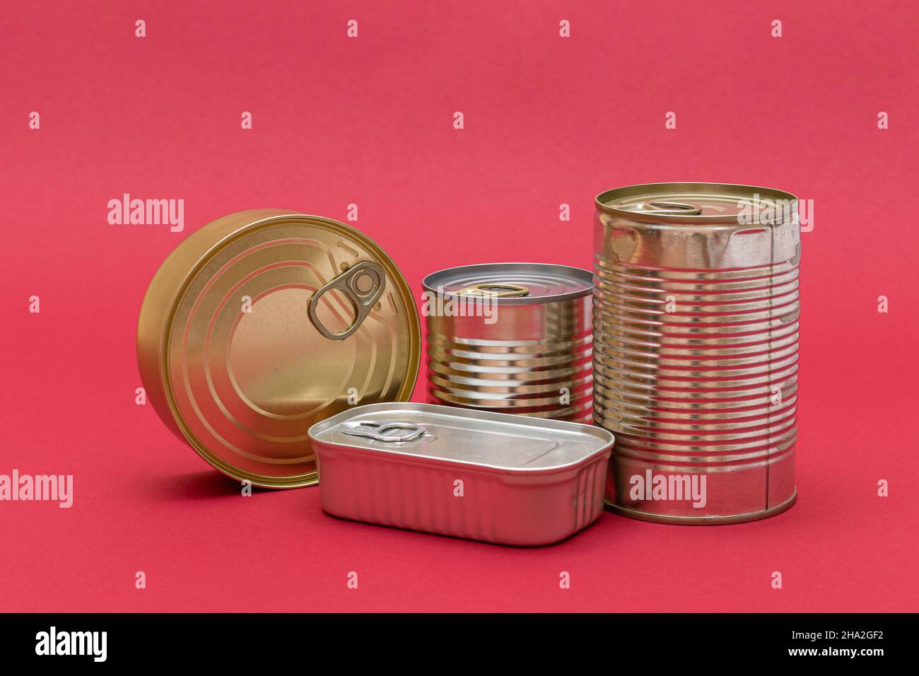 A Group of Stacked Tin Cans with Blank Edges on Red Background. Canned ...