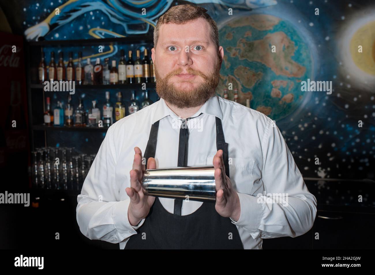 A bearded adult man of European appearance, a professional bartender ...