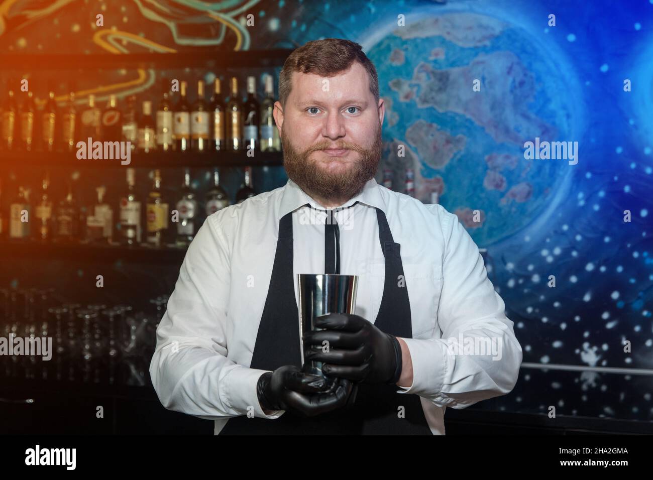 A bearded adult man of European appearance, a professional bartender ...