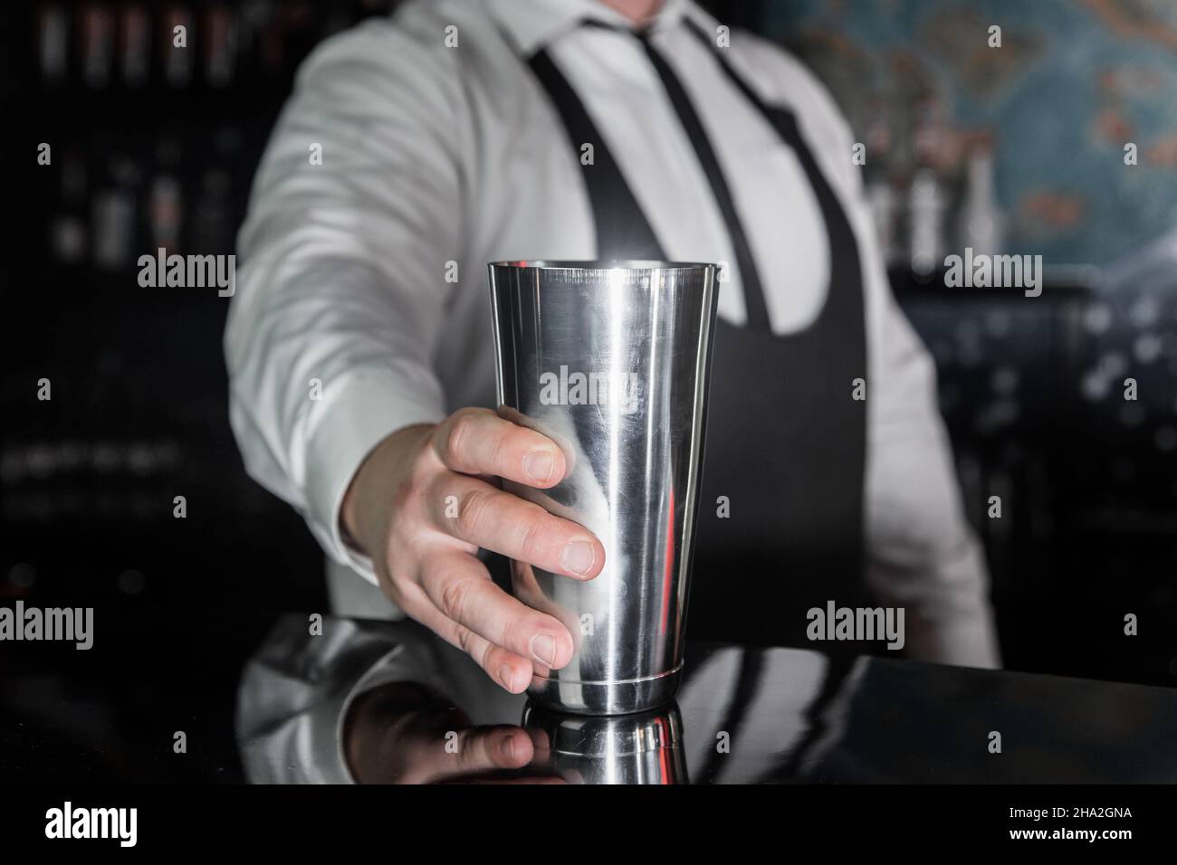 The hand of a professional bartender takes a tool for cooking and ...