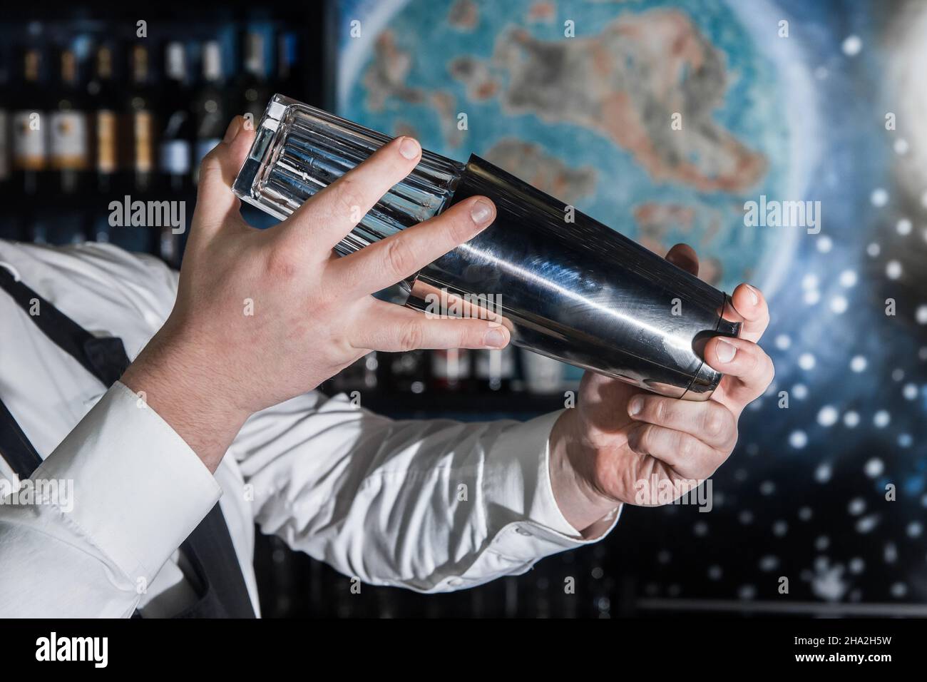 Hands of a professional bartender beat and mix ingredients in a tool ...