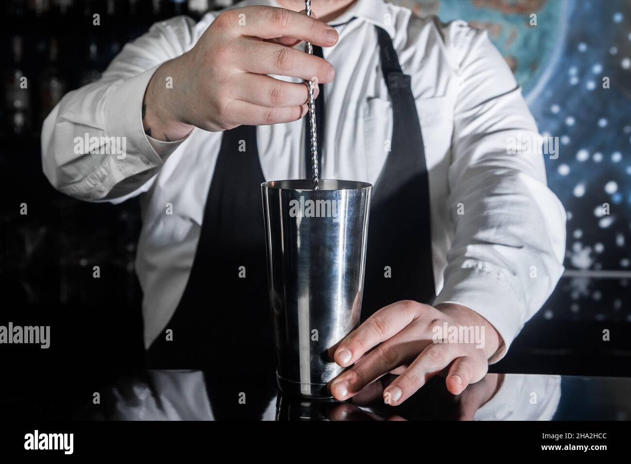 The hands of a professional bartender interfere with a bar spoon the ...