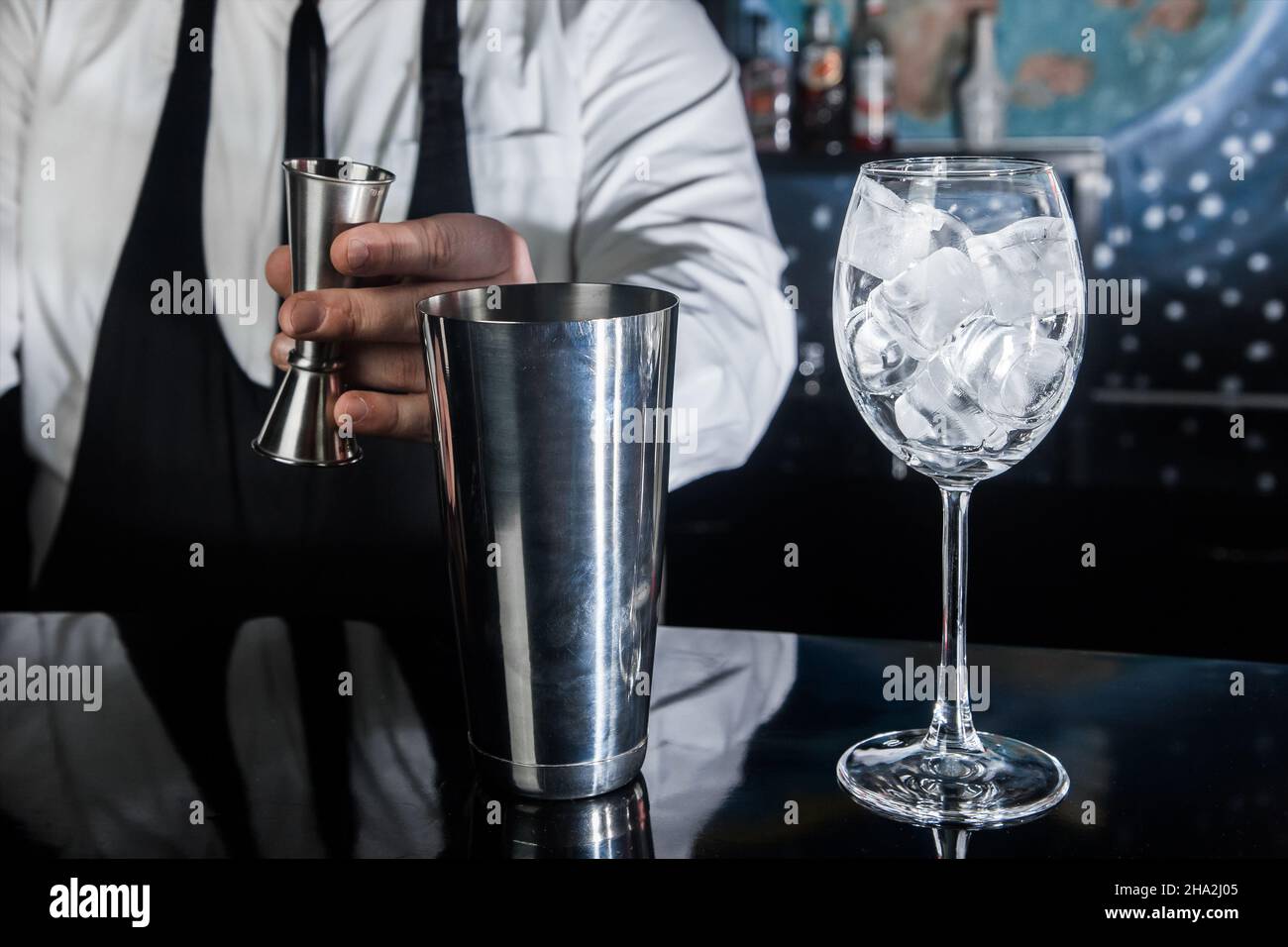The hands of a professional bartender pour syrup into a measuring glass ...
