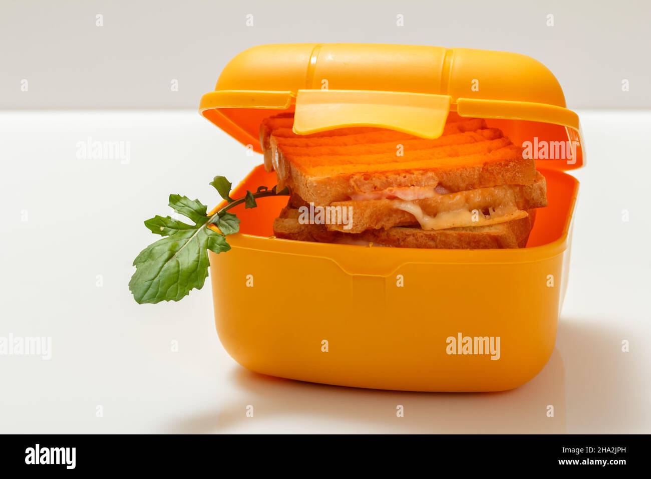 Yellow lunch box with toasted slices of bread, cheese Stock Photo - Alamy