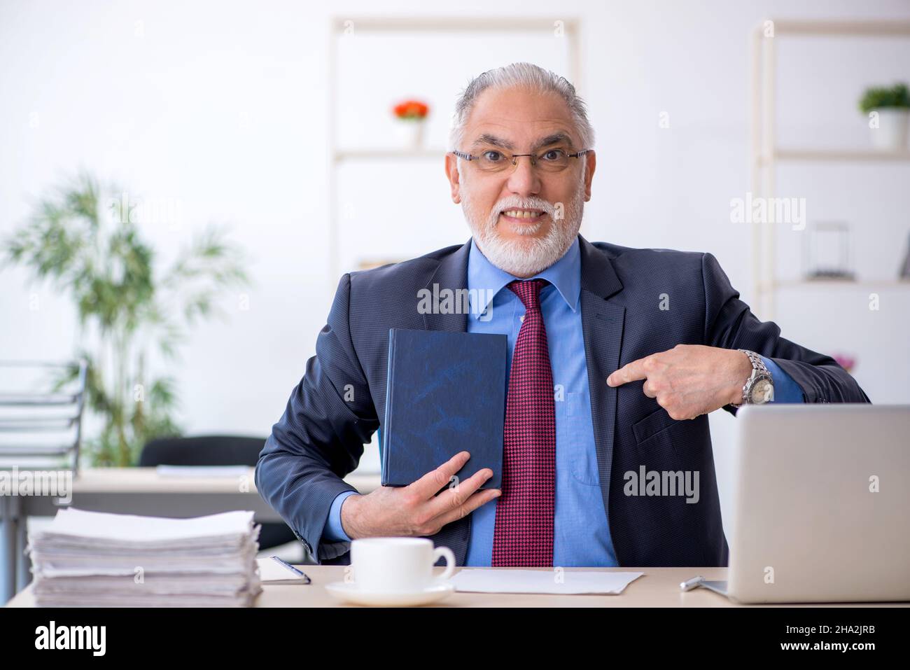 Old businessman employee reading book at workplace Stock Photo - Alamy
