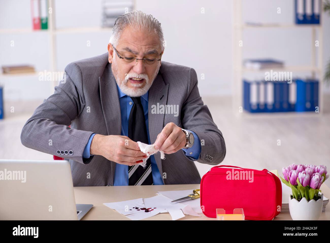 Old businessman employee cutting his hand at workplace Stock Photo - Alamy