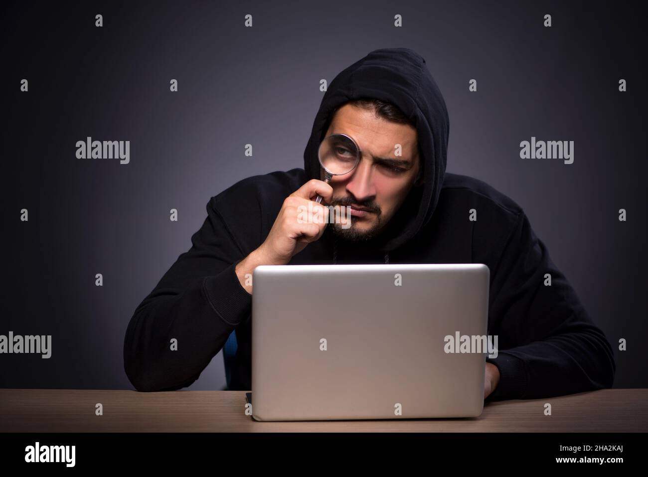 Young hacker on grey background Stock Photo - Alamy