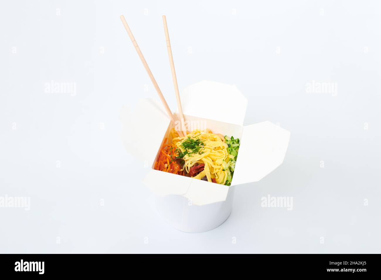 Rice wok with seafood and vegetables in white box and wooden chopsticks ...