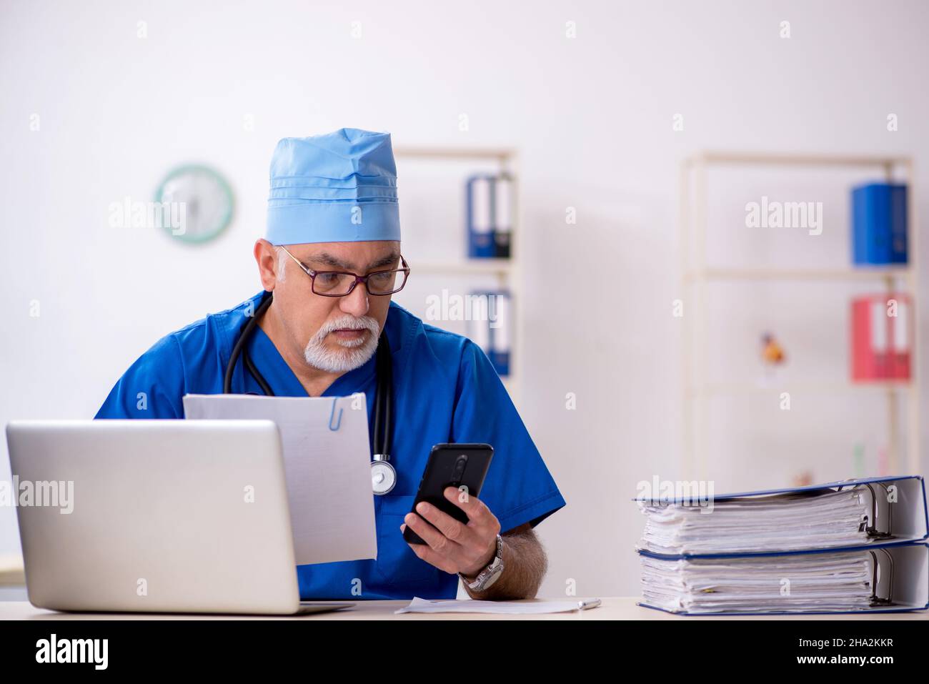 Old doctor working in the clinic Stock Photo - Alamy