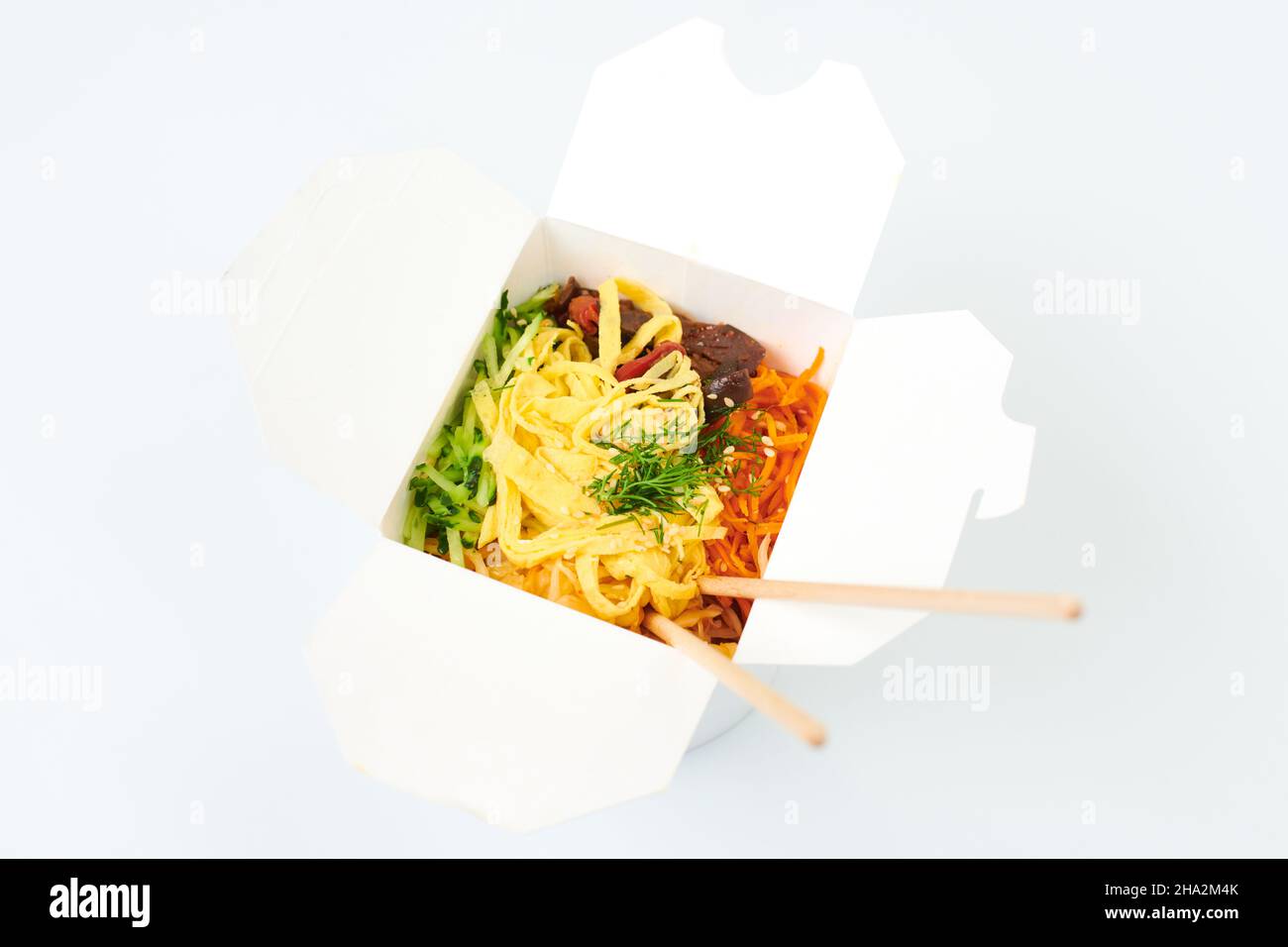 Rice wok with seafood and vegetables in white box and wooden chopsticks ...