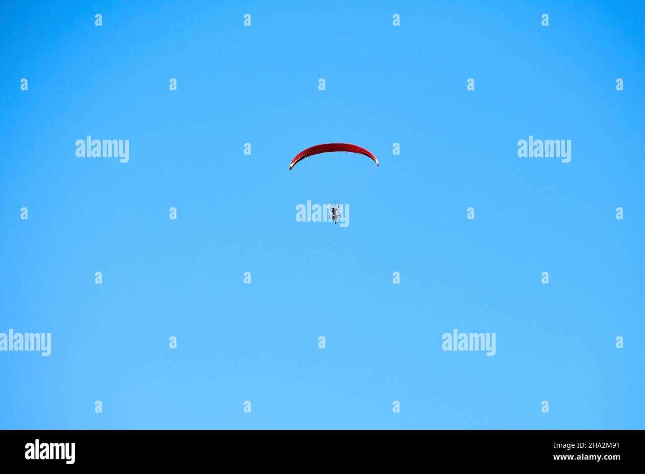 Powered parachute in clear blue sky, motorized parachute overhead view ...