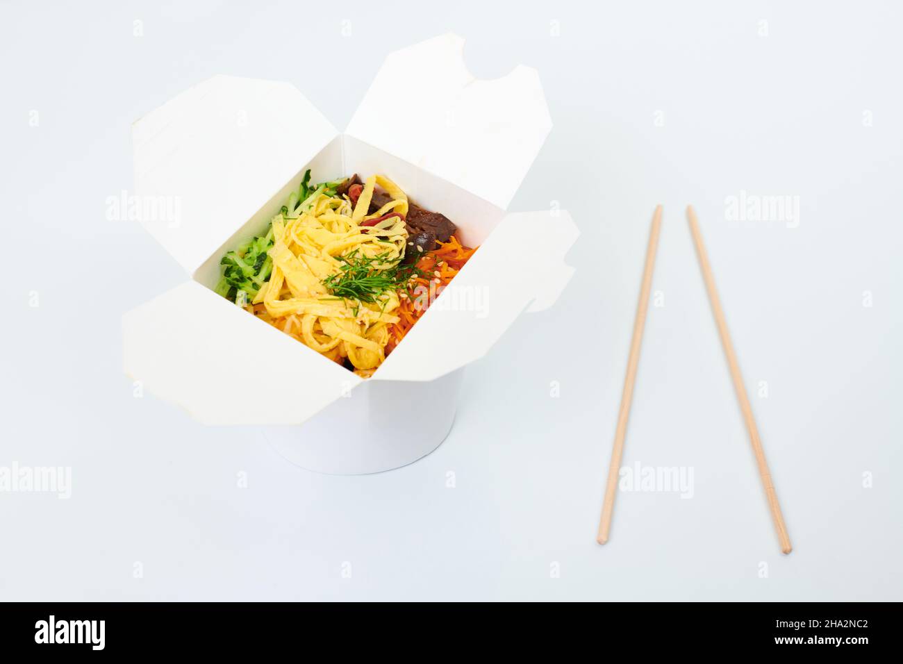 Rice wok with seafood cocktail and vegetables in box and wooden ...