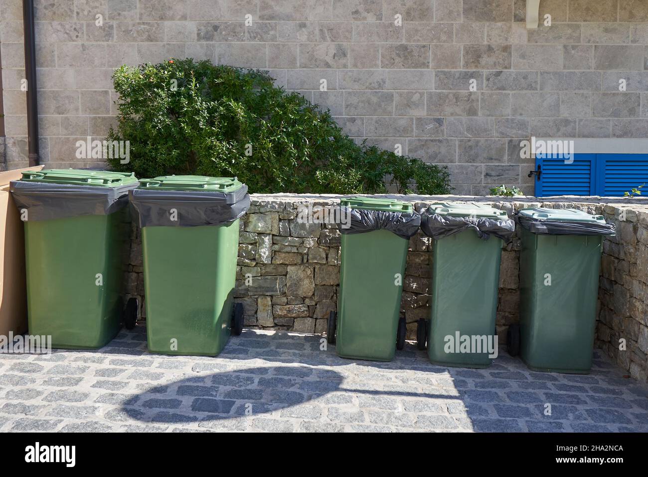 Green trash bins in a special place Stock Photo - Alamy