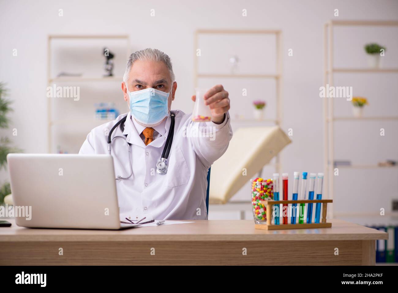 Old doctor working in the clinic during pandemic Stock Photo - Alamy