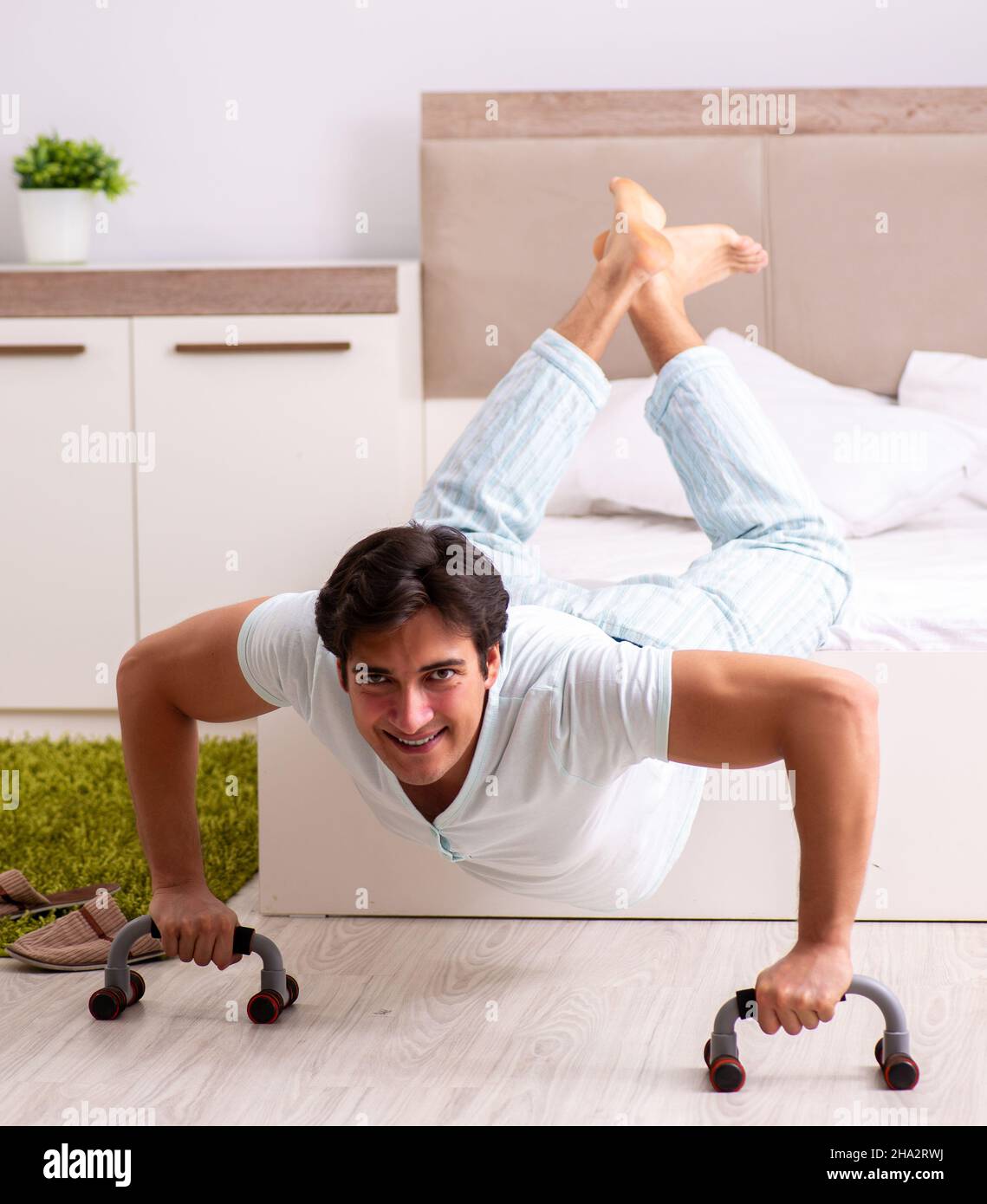 The young man doing morning routine in bedroom Stock Photo - Alamy