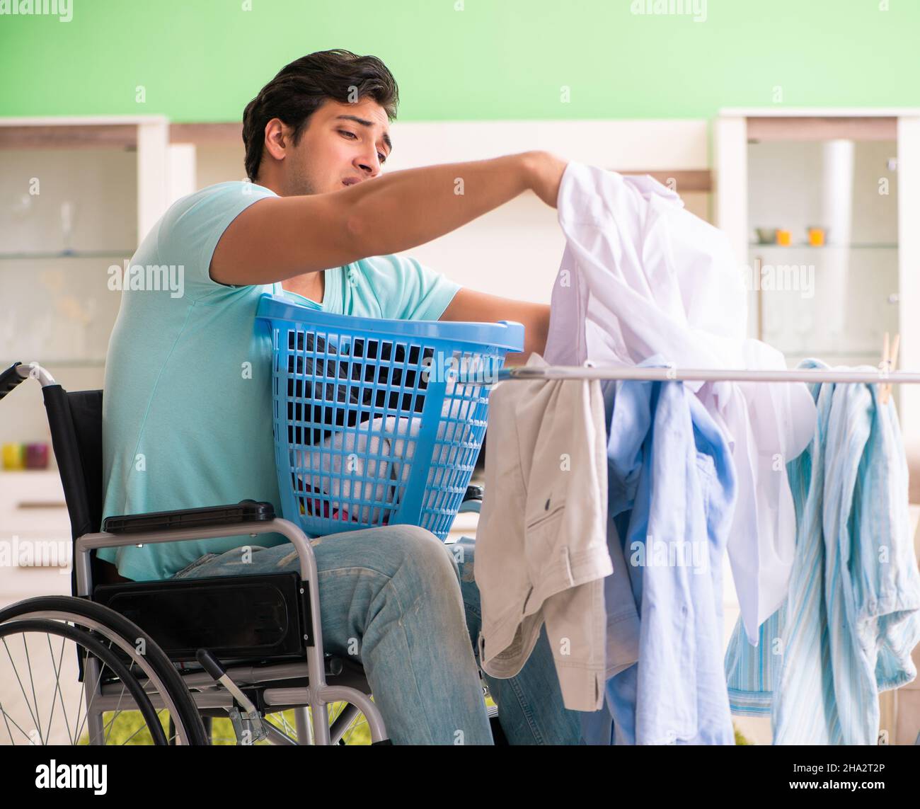 The disabled man on wheelchair doing laundry Stock Photo - Alamy