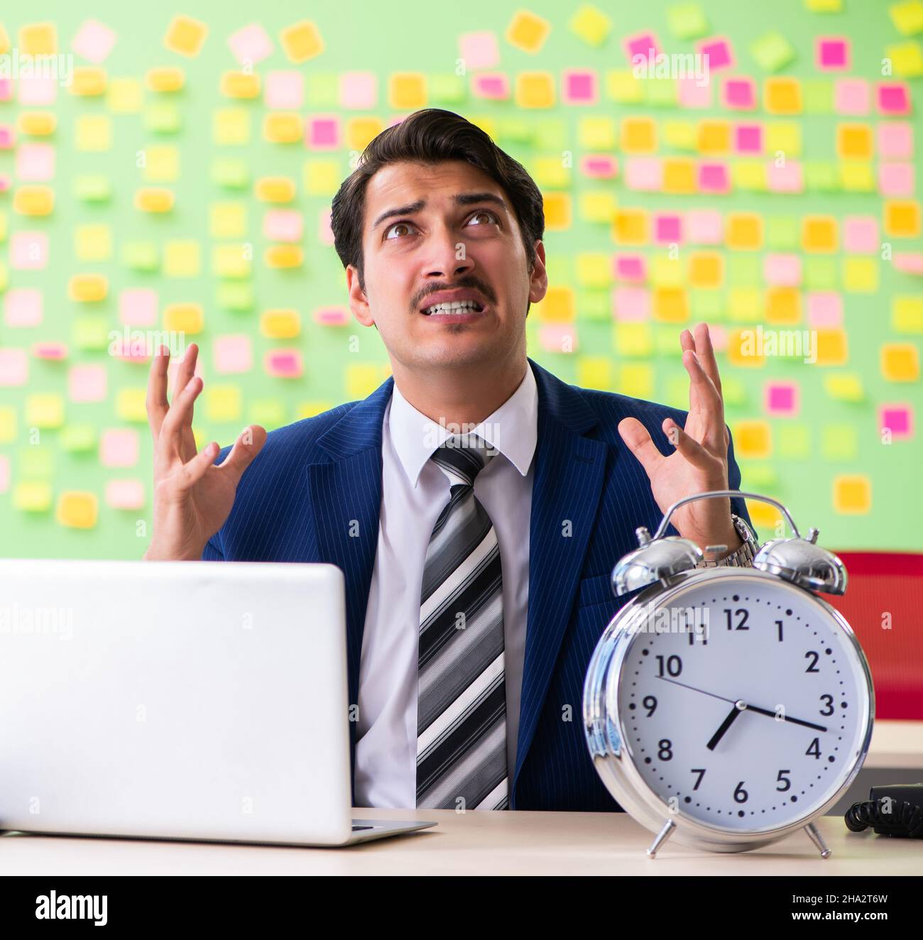 Businessman with many conflicting priorities in time management concept ...