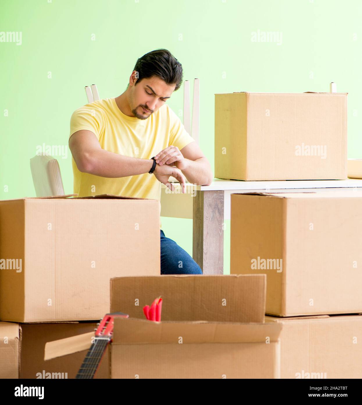 The young handsome man moving in to new house with boxes Stock Photo ...