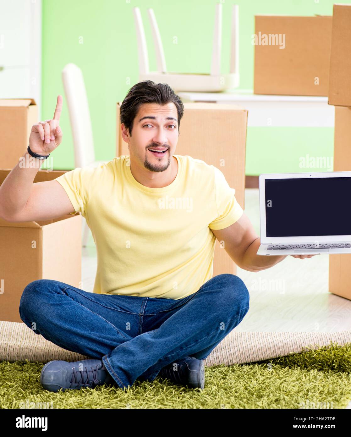 The young handsome man moving in to new house with boxes Stock Photo ...