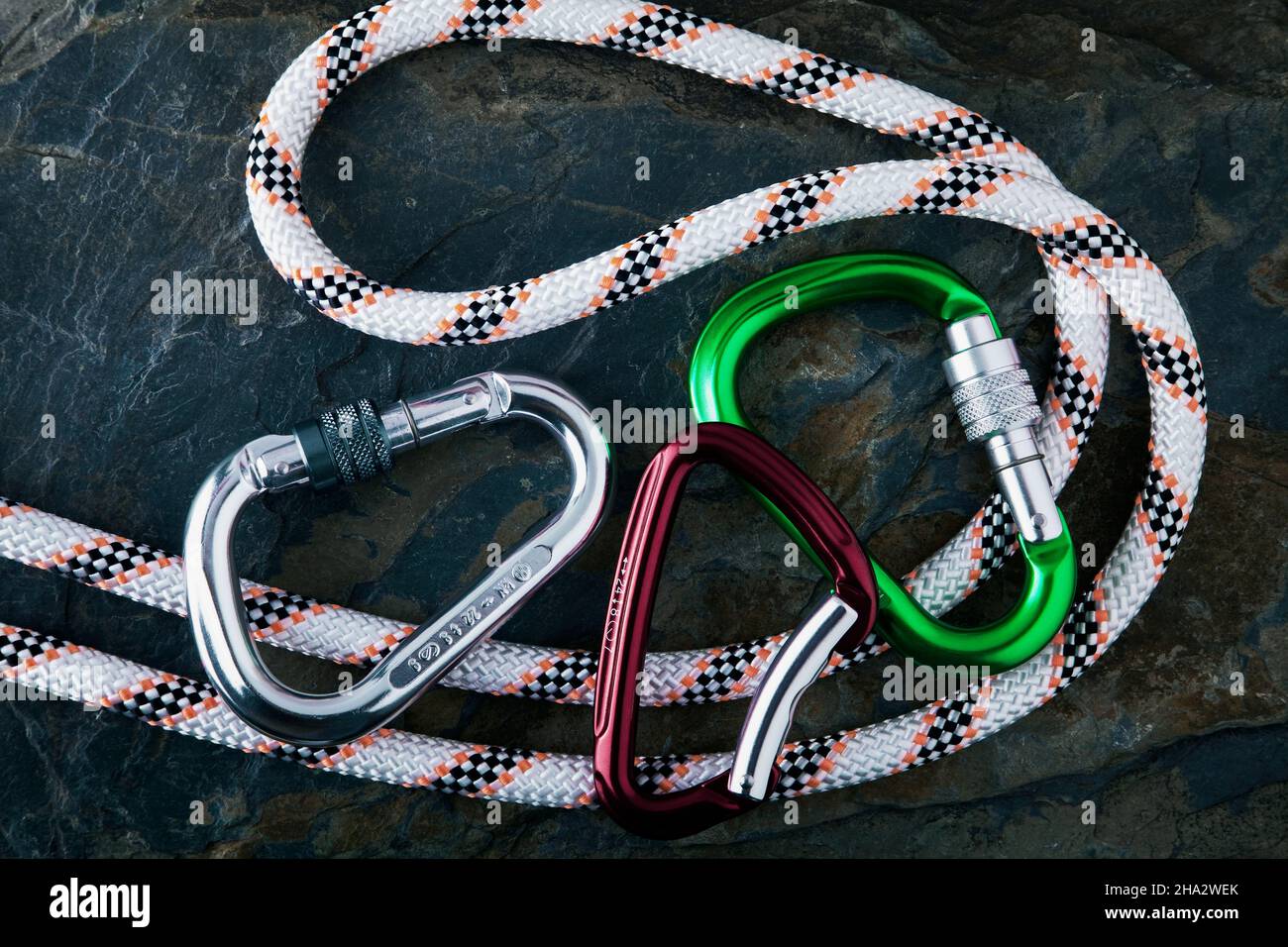 three carabiners with rope on a stone surface Stock Photo - Alamy