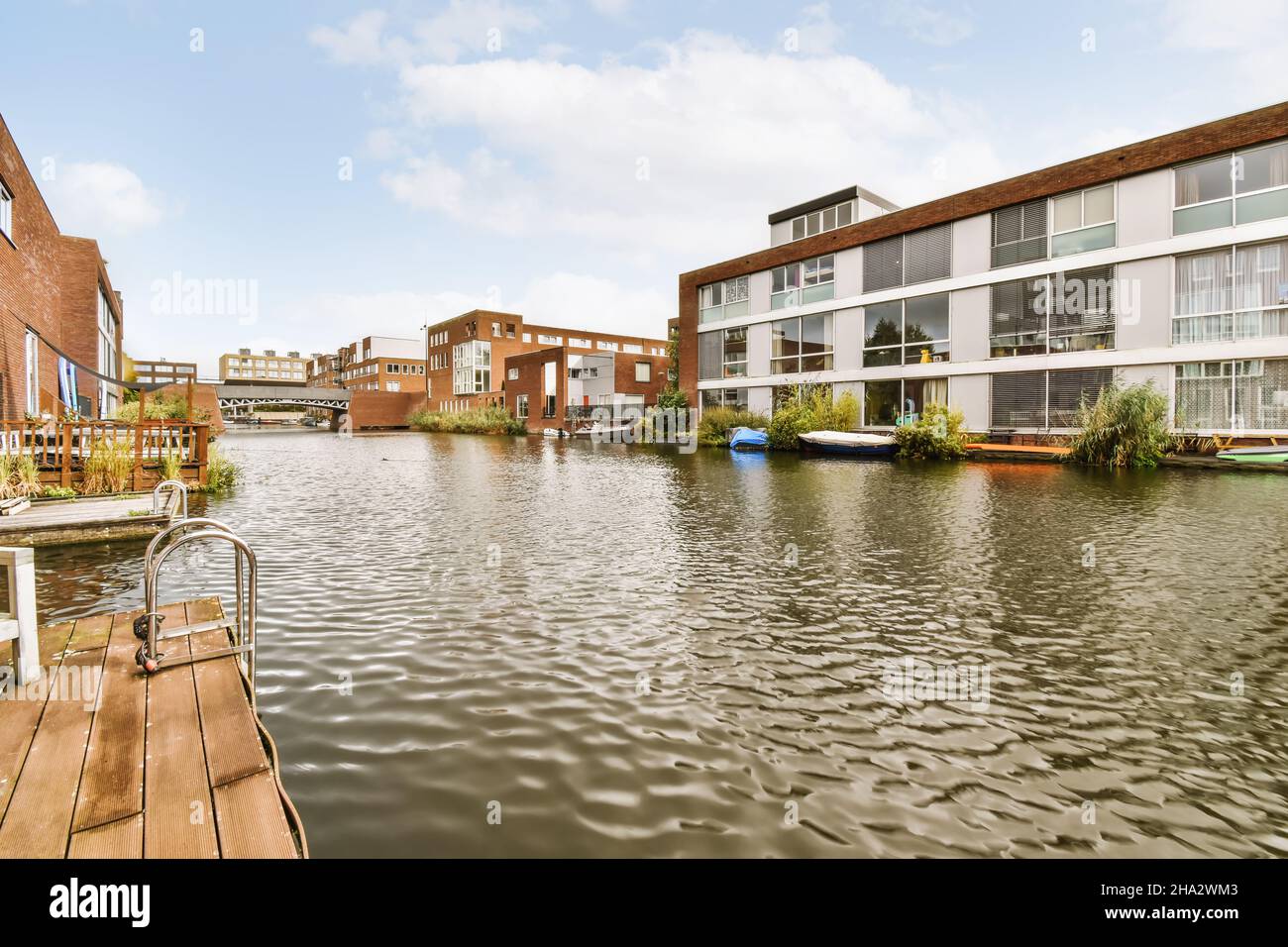 Adorable wooden boathouse in front of brick houses Stock Photo - Alamy