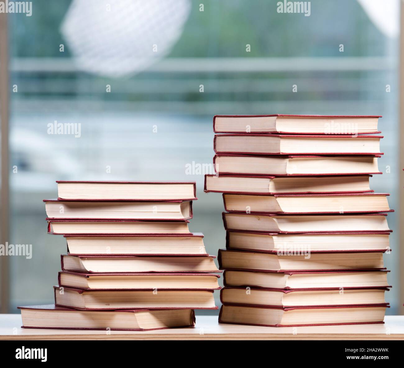 The stack of books arranged the office desk Stock Photo - Alamy