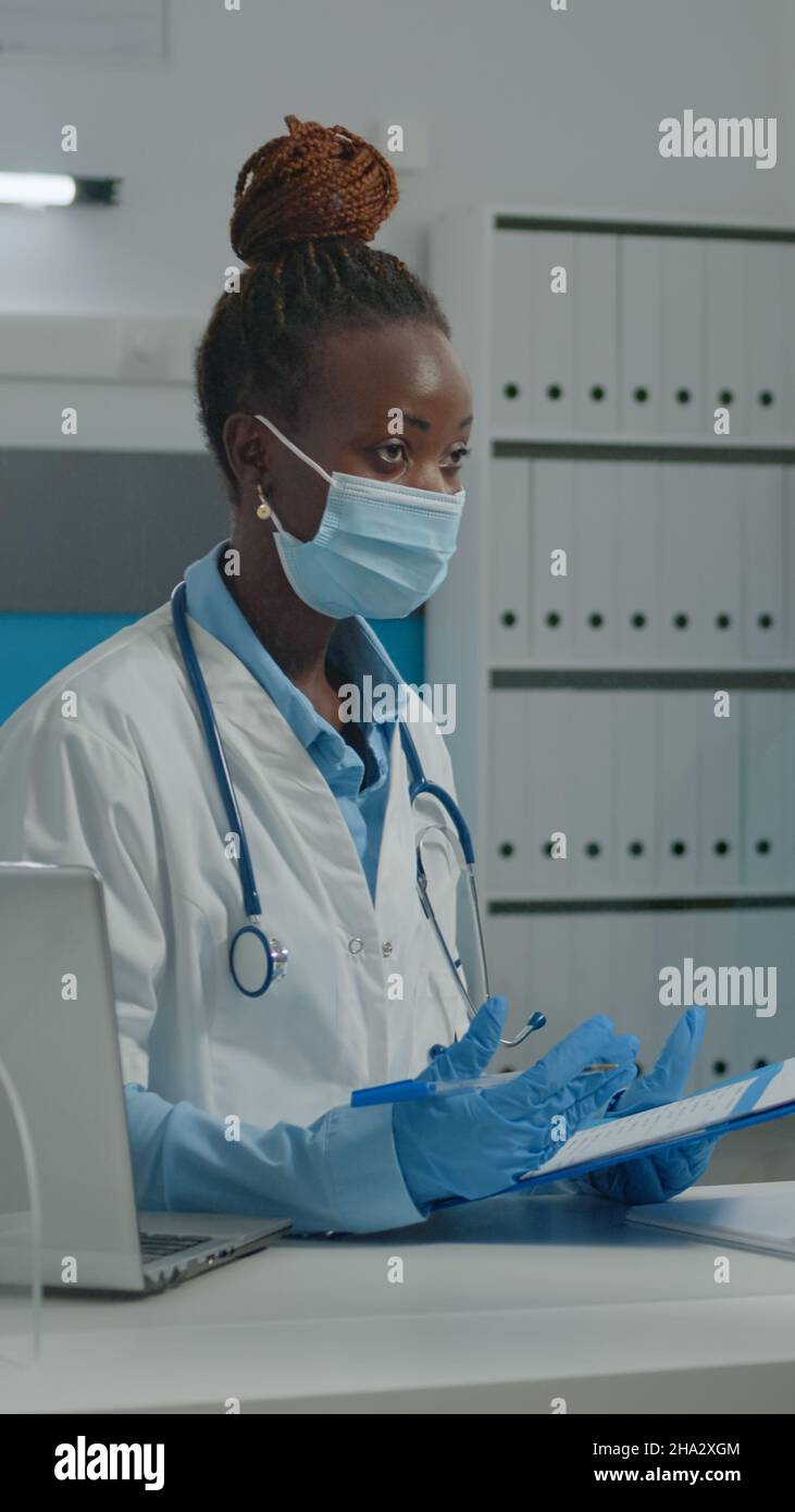 Doctor writing information on checkup papers for elderly man with ...