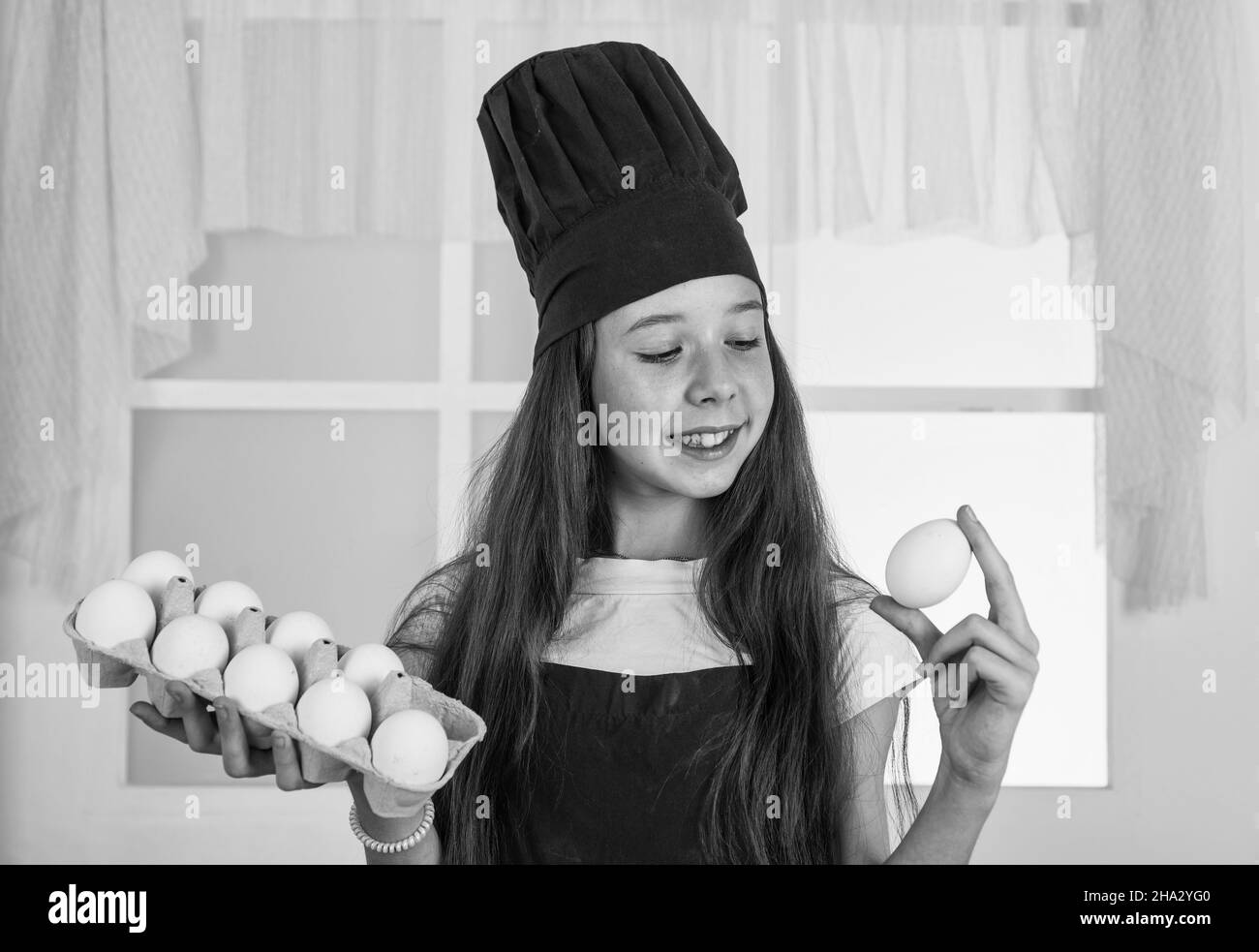preparing from eggs. happy child wear cook uniform. chef girl in hat ...
