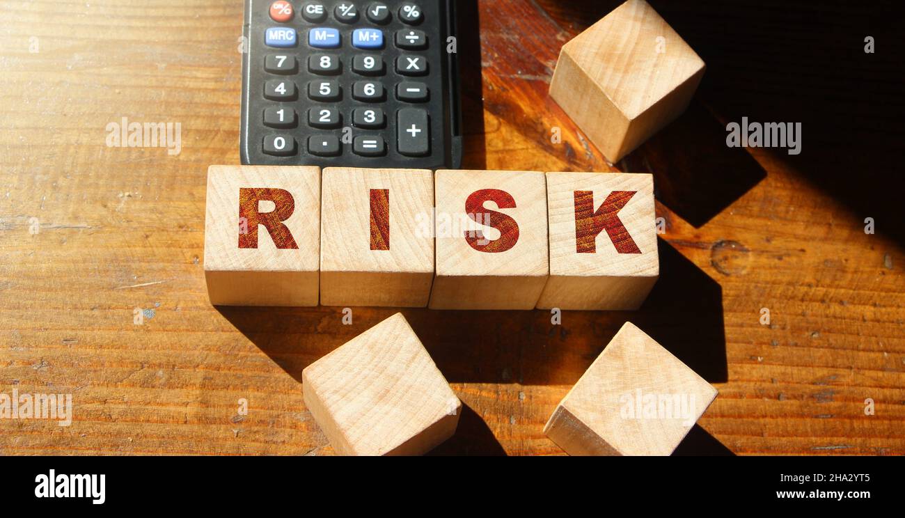 RISK word written on wooden cubes and calculator. Financial risk ...