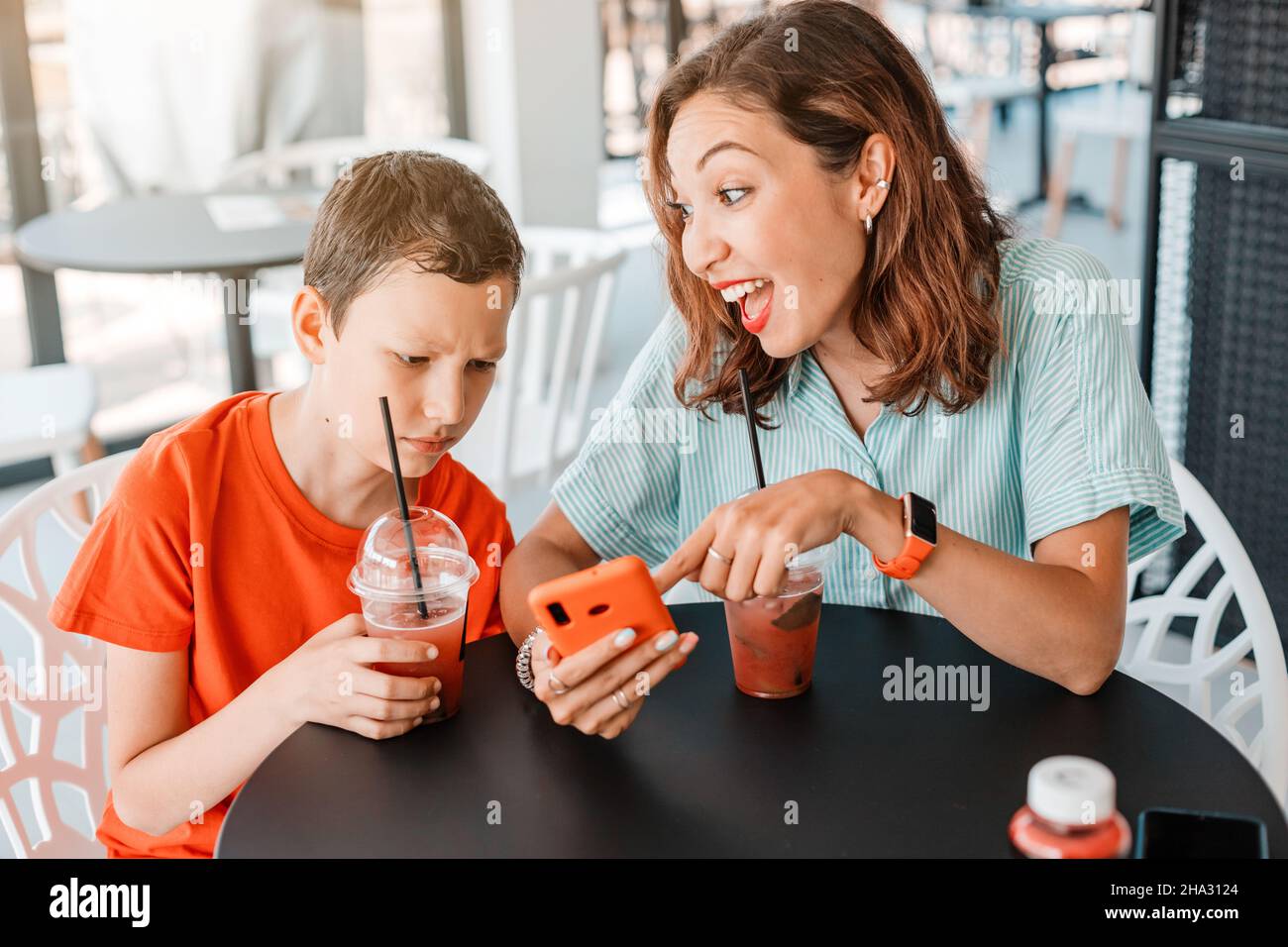 Mother shows her son funny memes on smartphone screen, but her son does ...
