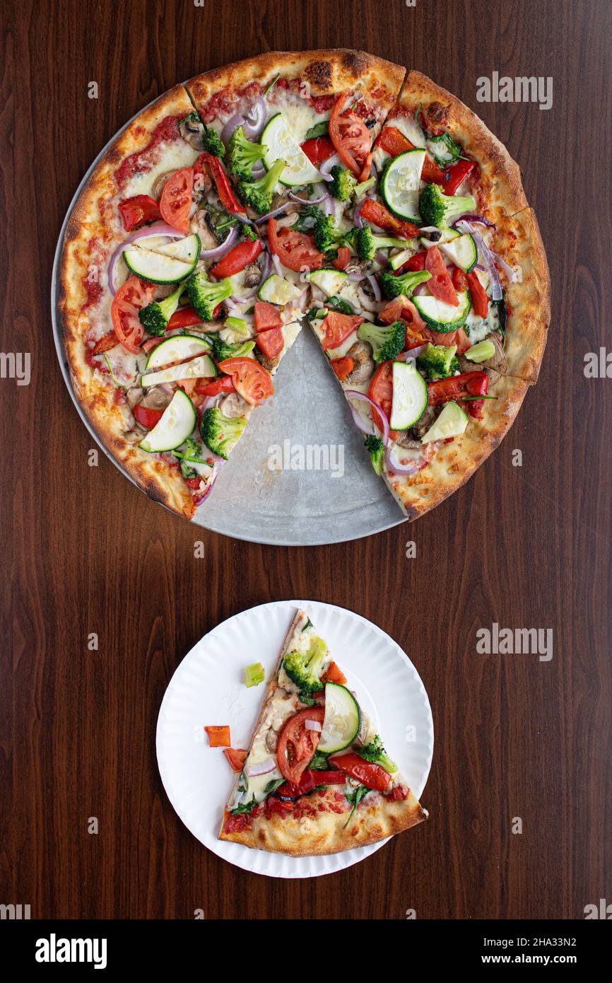 Vertical top view of a vegetable pizza with a slice cut out Stock Photo ...