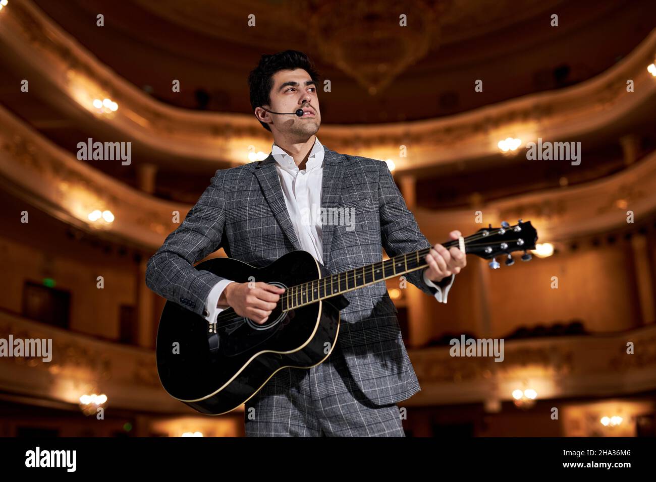 american brunette Guitar player in elegant classic suit performing ...