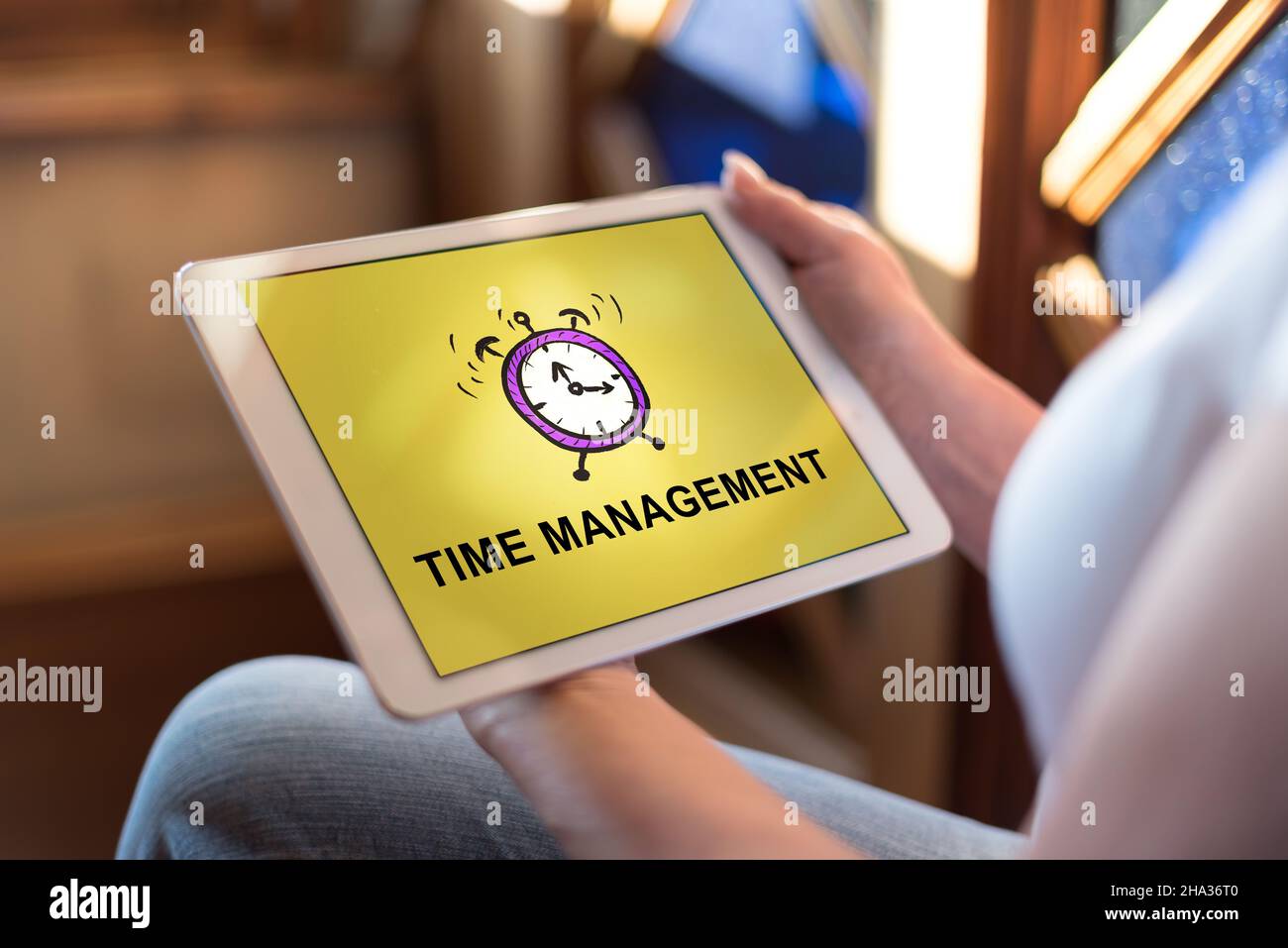 Woman holding a tablet showing time management concept Stock Photo - Alamy