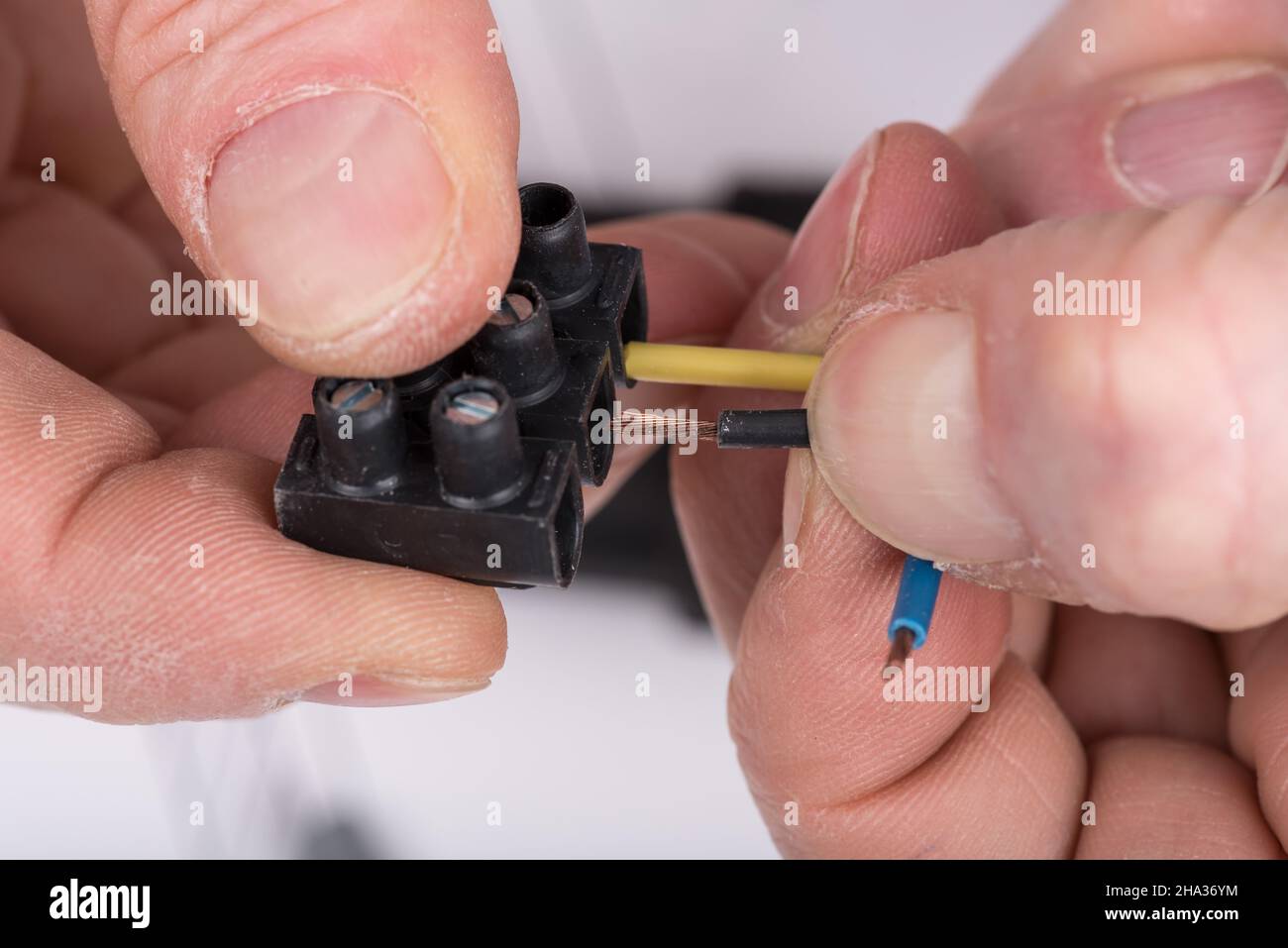 Hand putting a wire in a connector Stock Photo - Alamy