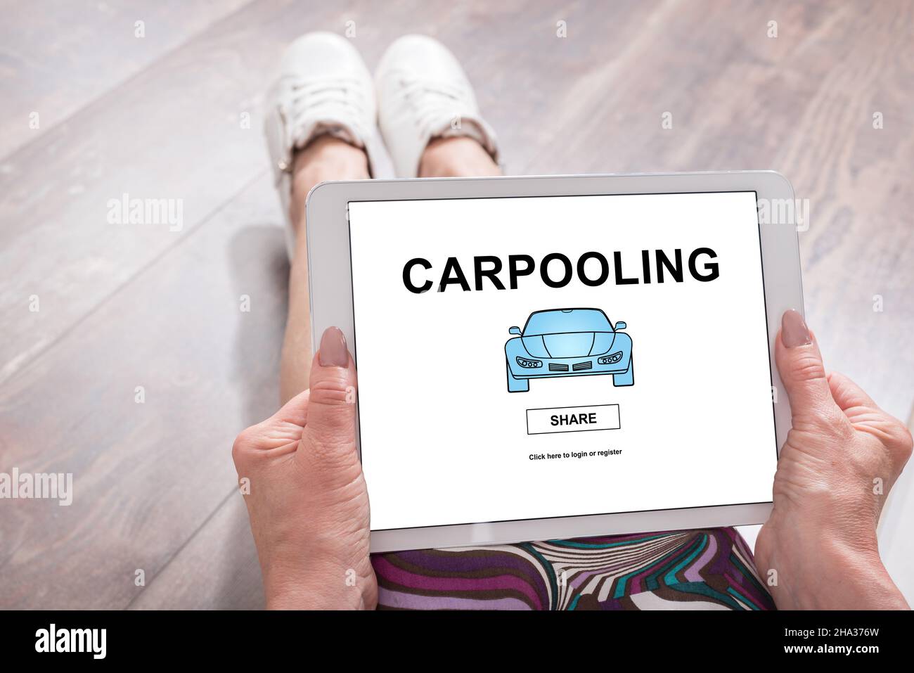 Woman sitting on the floor with a tablet showing carpooling concept ...