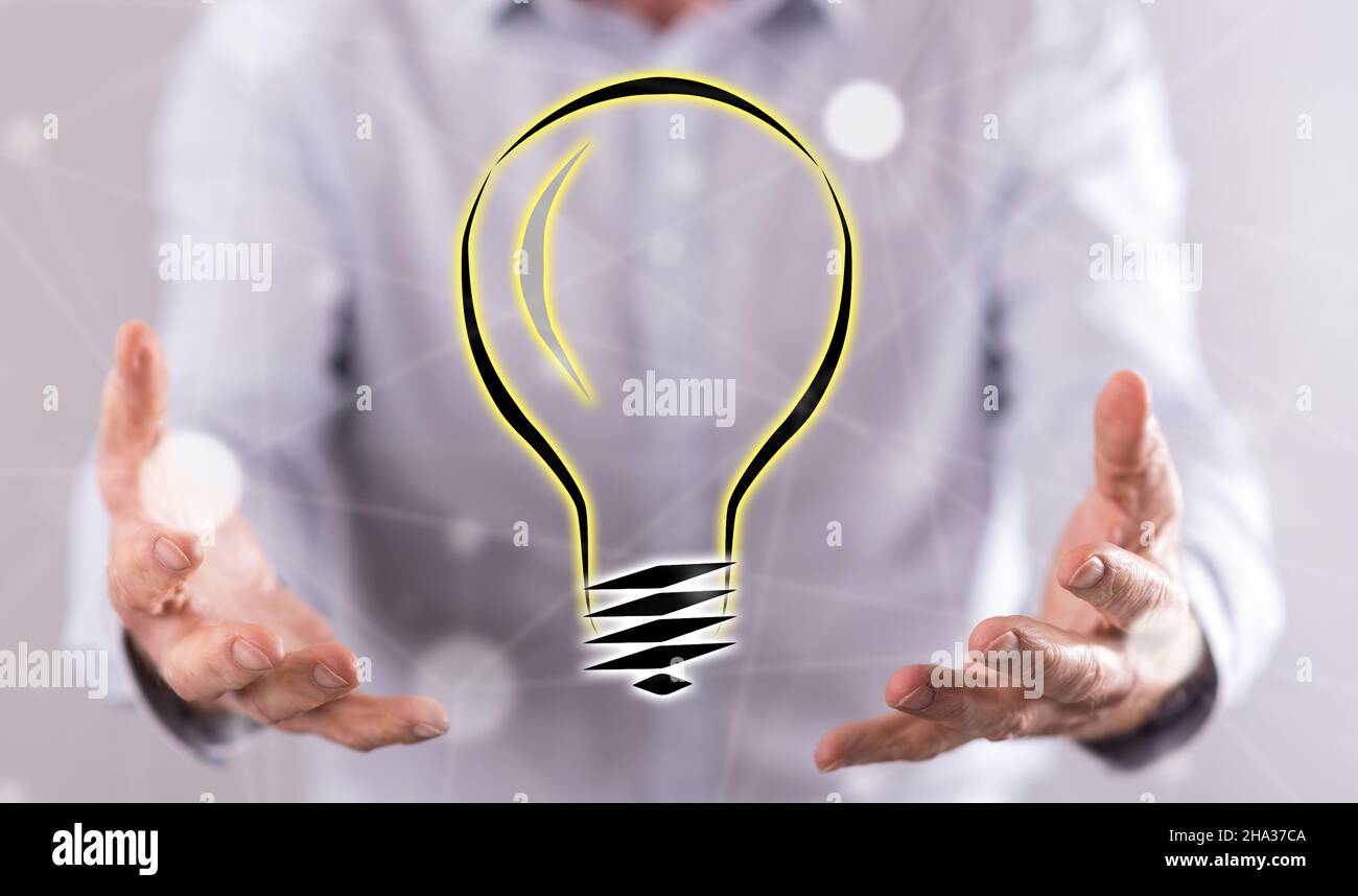 Bright idea concept above the hands of a man in background Stock Photo ...