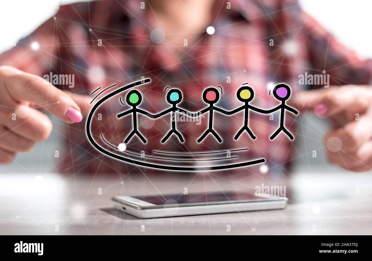 Smartphone with teamwork concept between hands of a woman in background ...